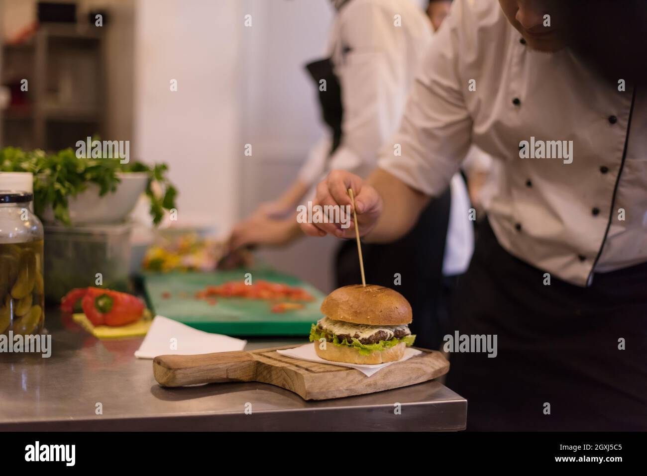 master chef putting toothpick on a burger in the kitchen Stock Photo ...