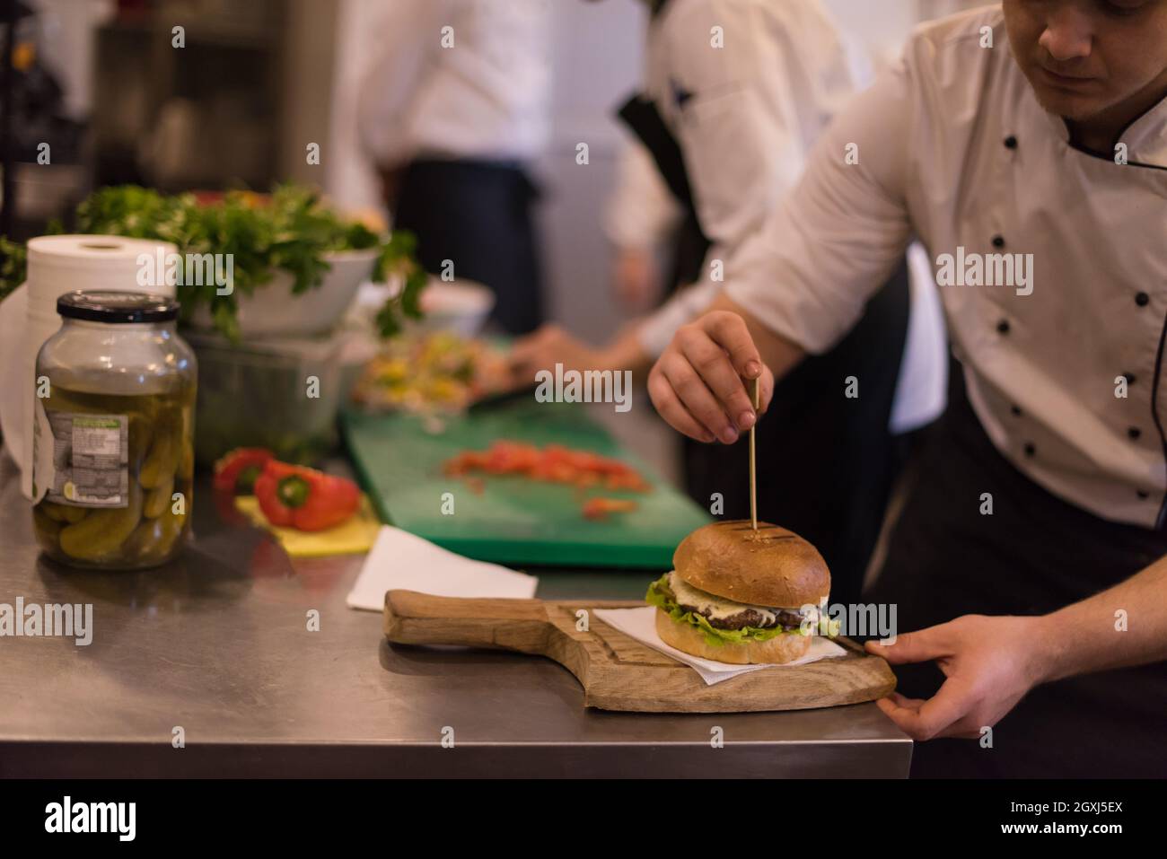 master chef putting toothpick on a burger in the kitchen Stock Photo ...