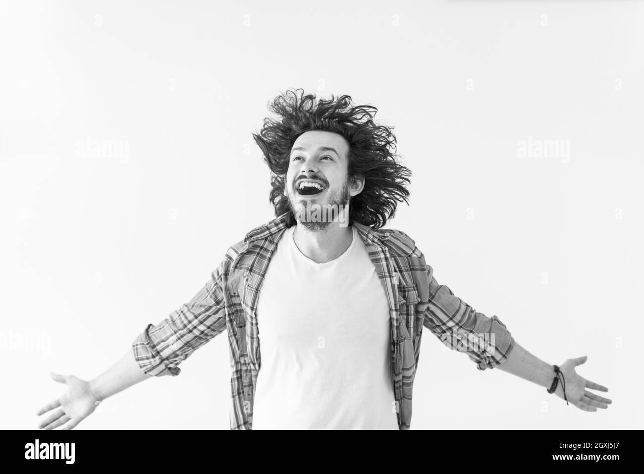 Portrait of an excited casual man standing with open arms and looking ...