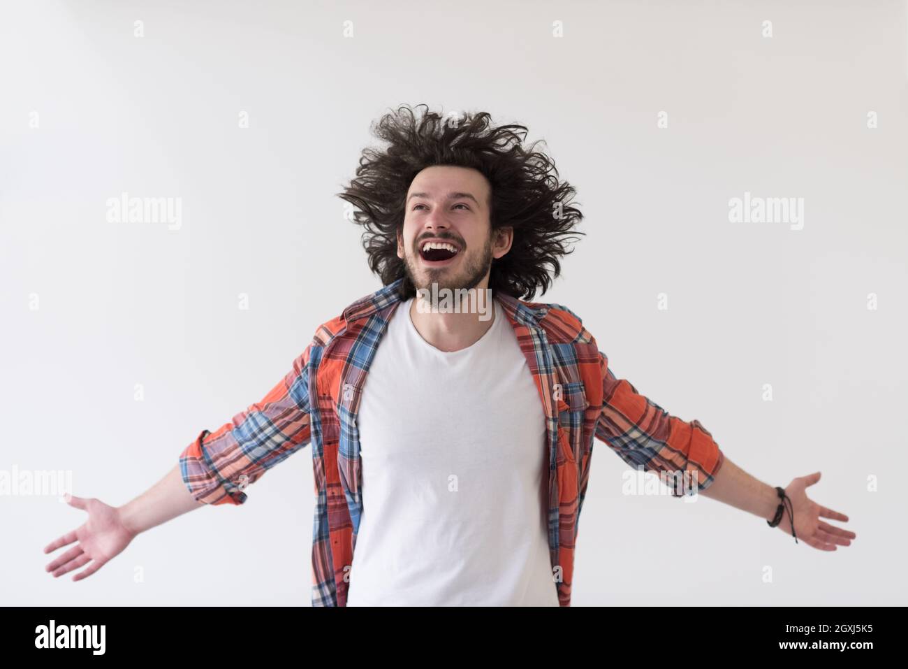 Portrait of an excited casual man standing with open arms and looking ...