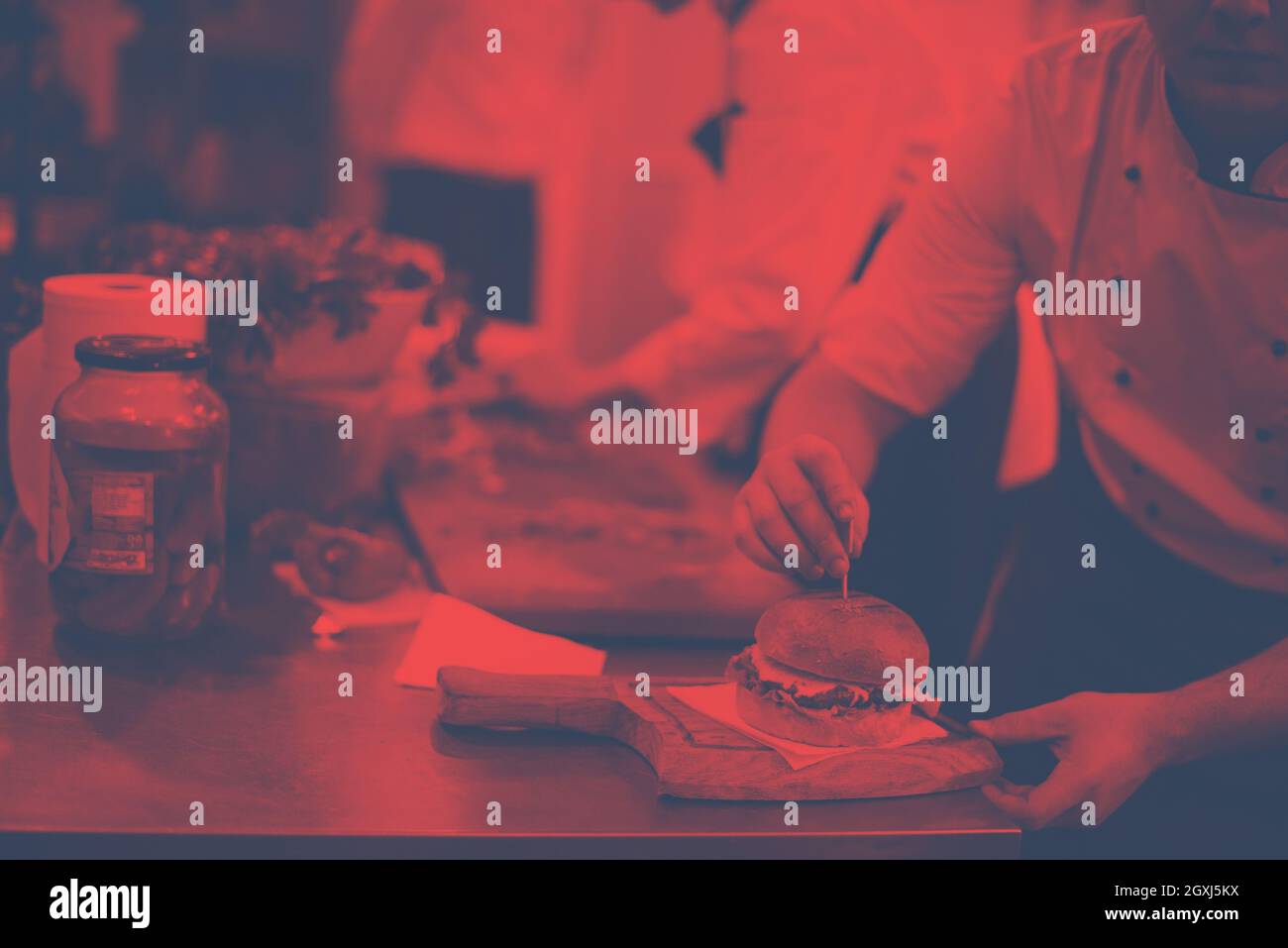 master chef putting toothpick on a burger in restaurant kitchen Stock ...