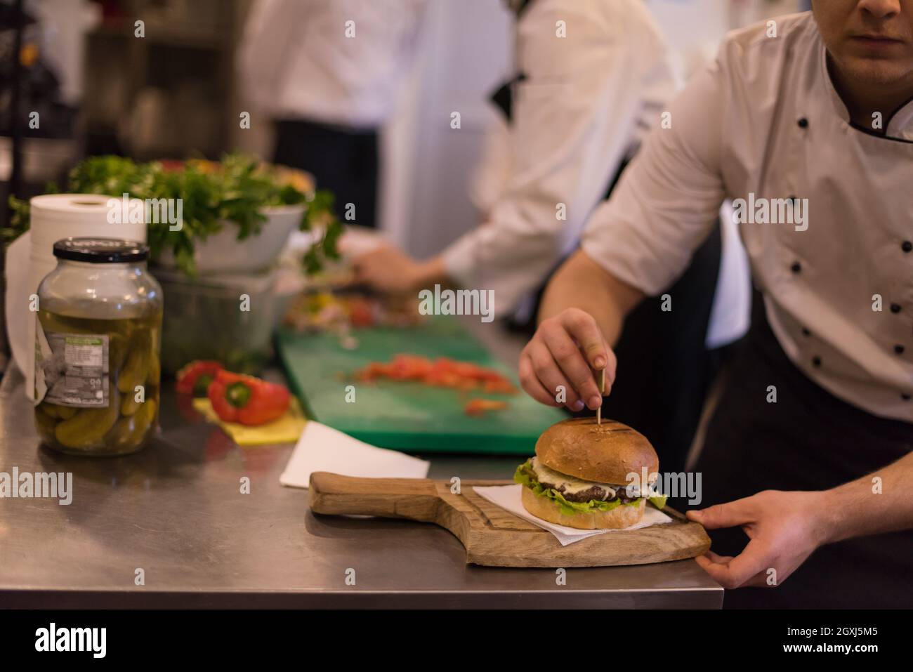 master chef putting toothpick on a burger in the kitchen Stock Photo ...