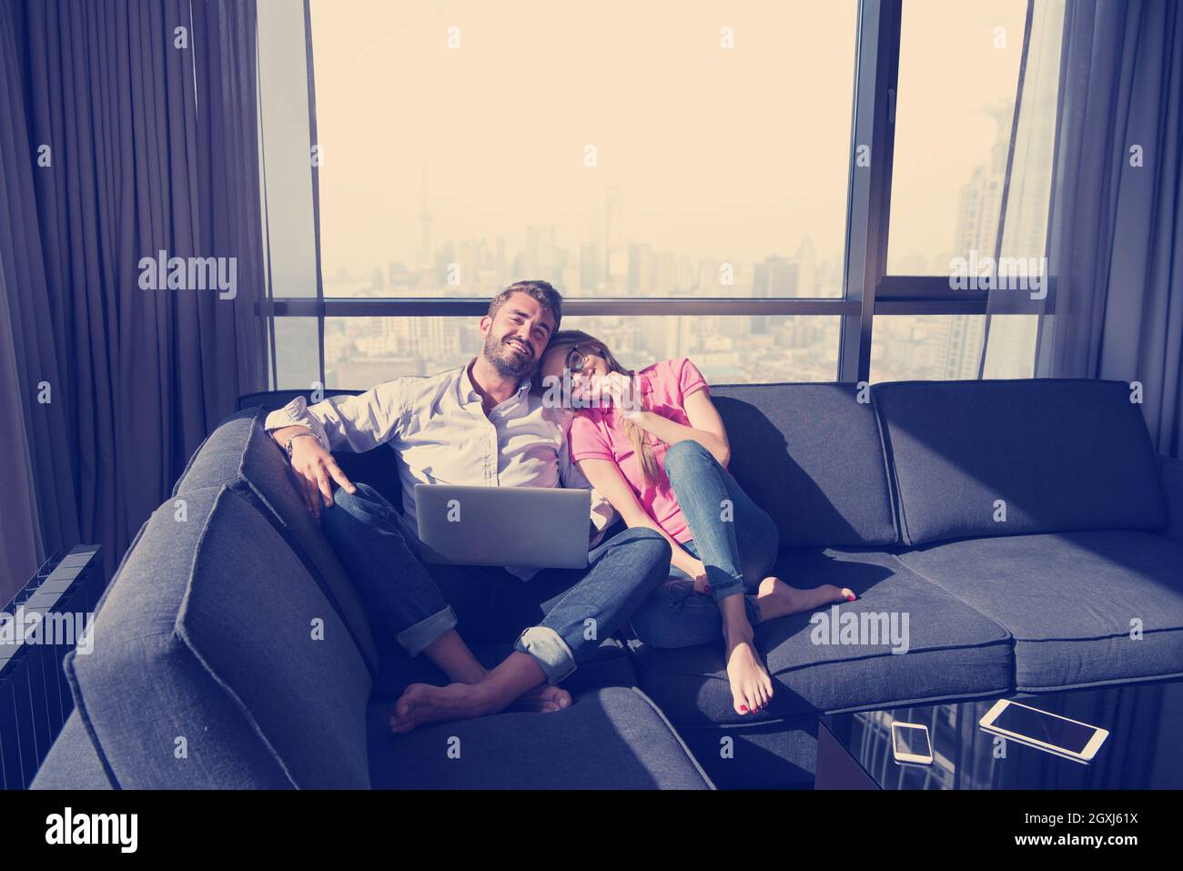 Young couple relaxing at home using laptop computers reading in the ...