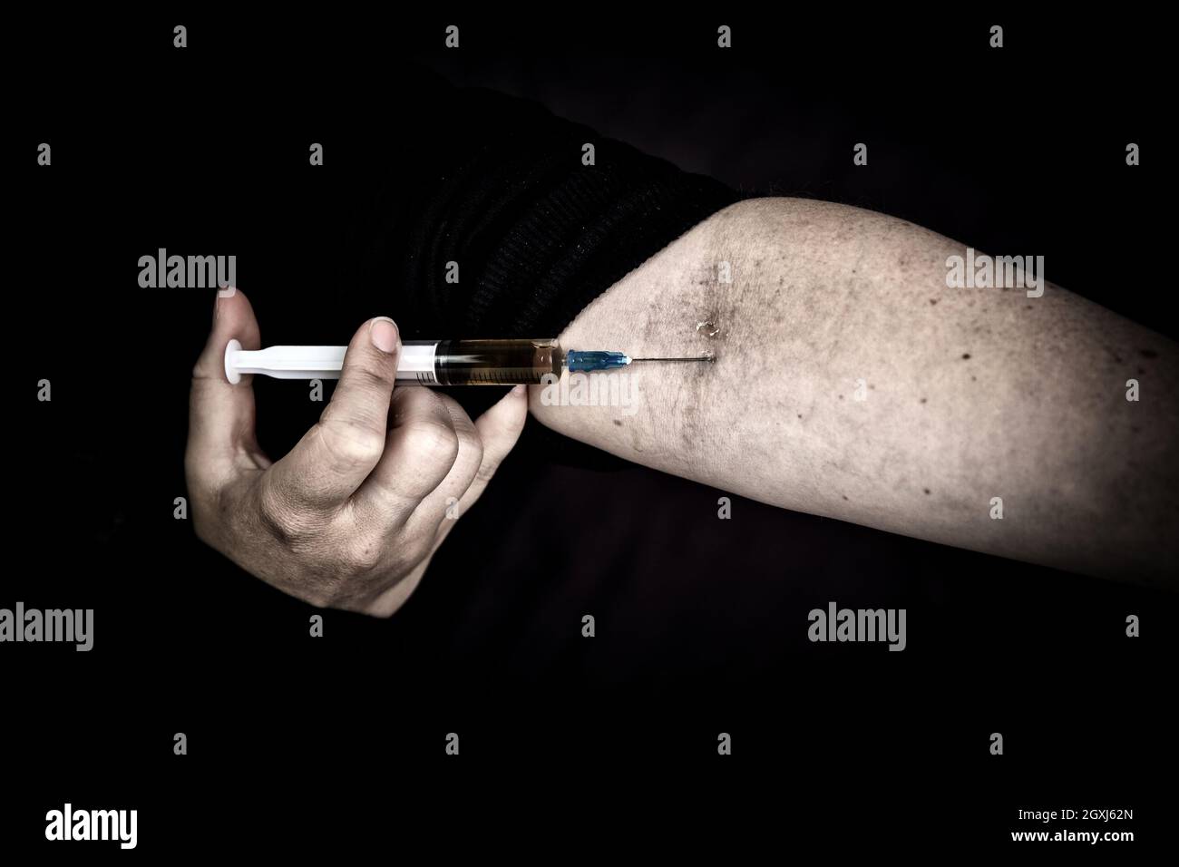 heroin addiction Junky shooting up Horse with syringe on dark ...