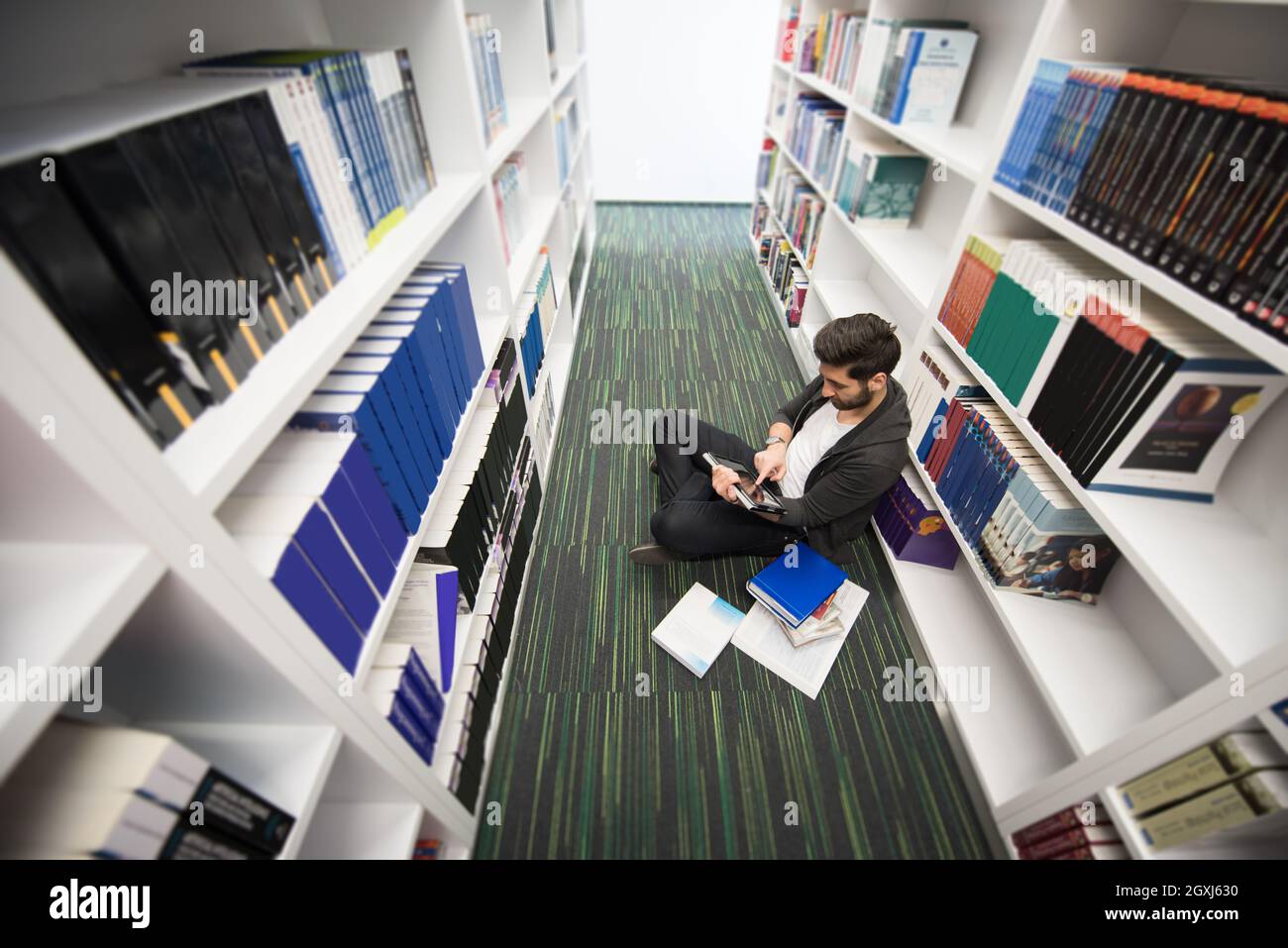 Student reading book in school library. Study lessons for exam. Hard ...