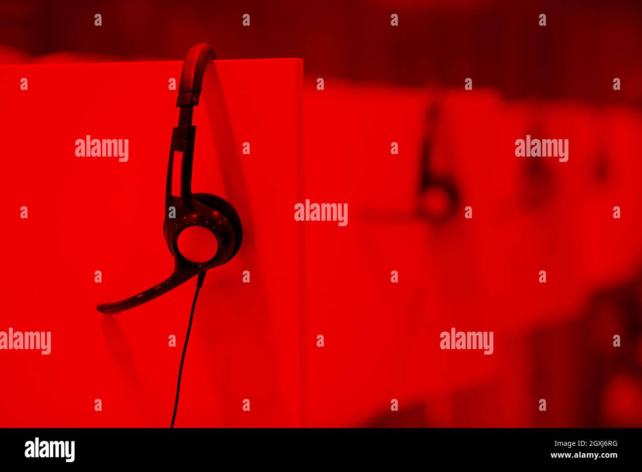 Headphones hanging on cubicle partition in empty call center office ...