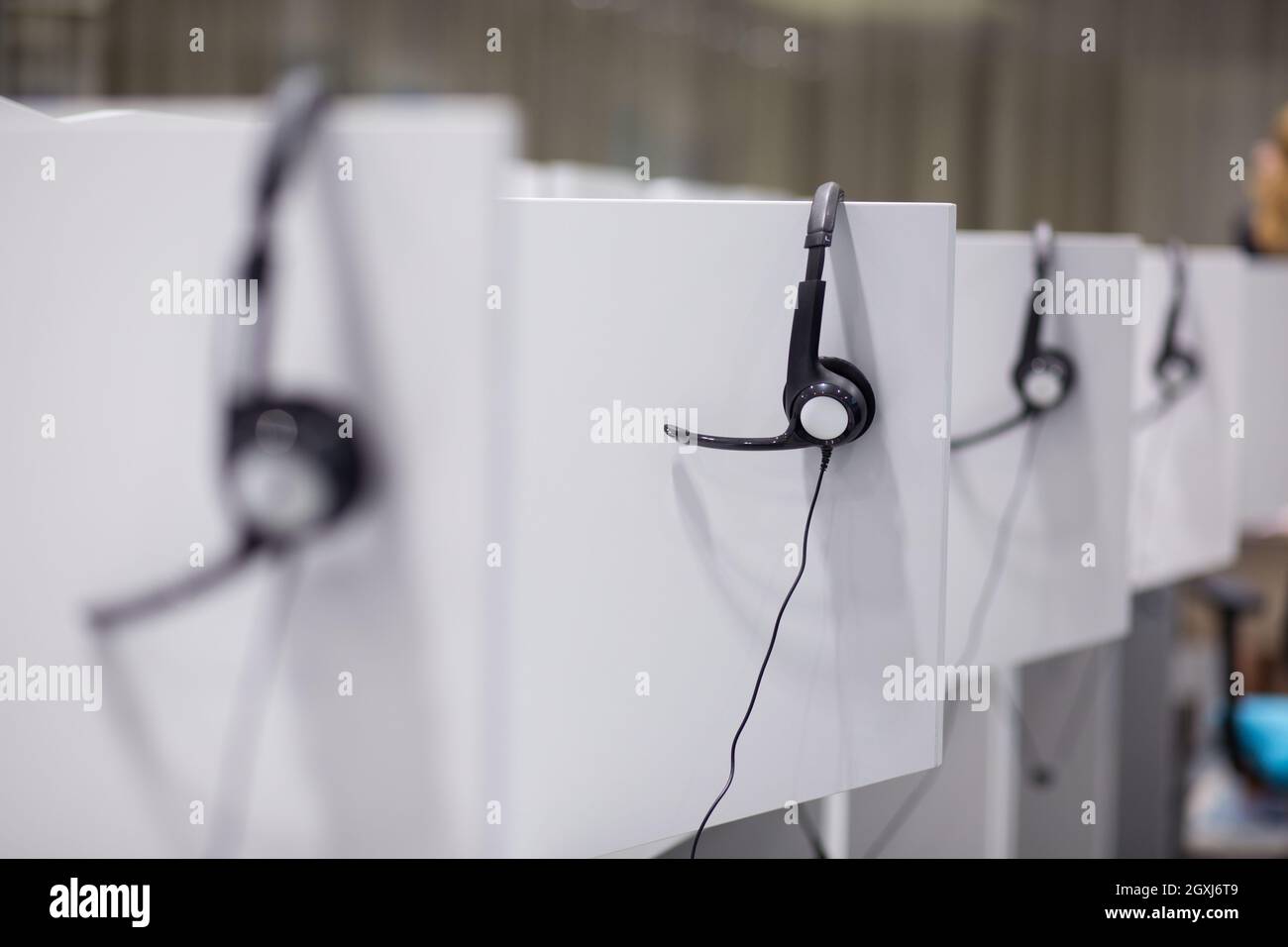Headphones hanging on cubicle partition in empty call center office ...