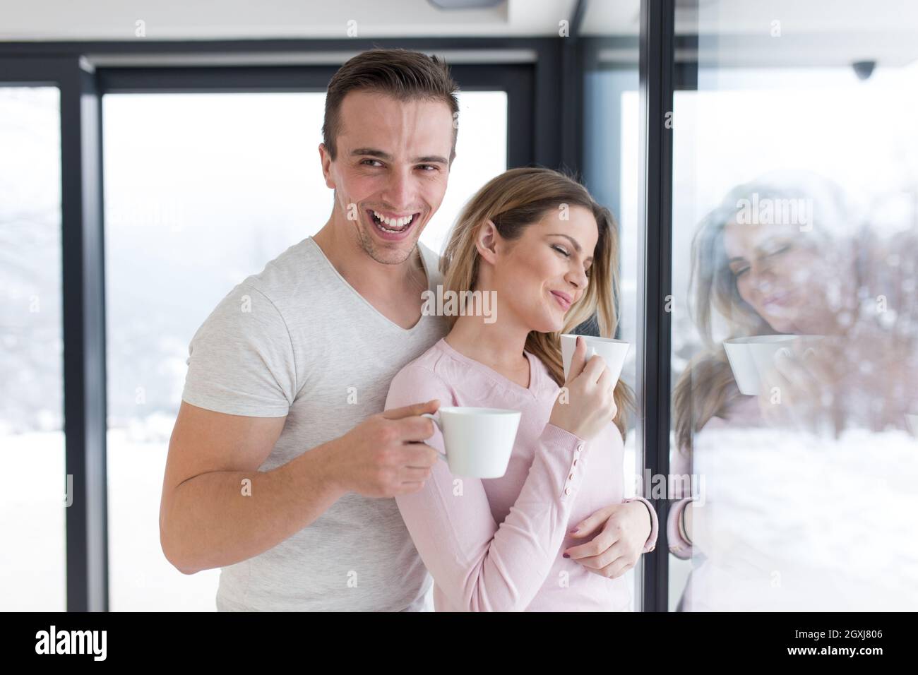 romantic happy young couple enjoying morning coffee by the window on ...