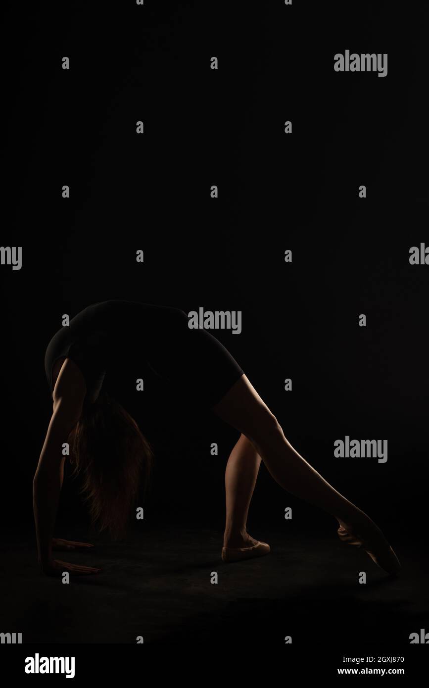 Suilhouette of ballerina in perfect bend pose on the ground Stock Photo ...