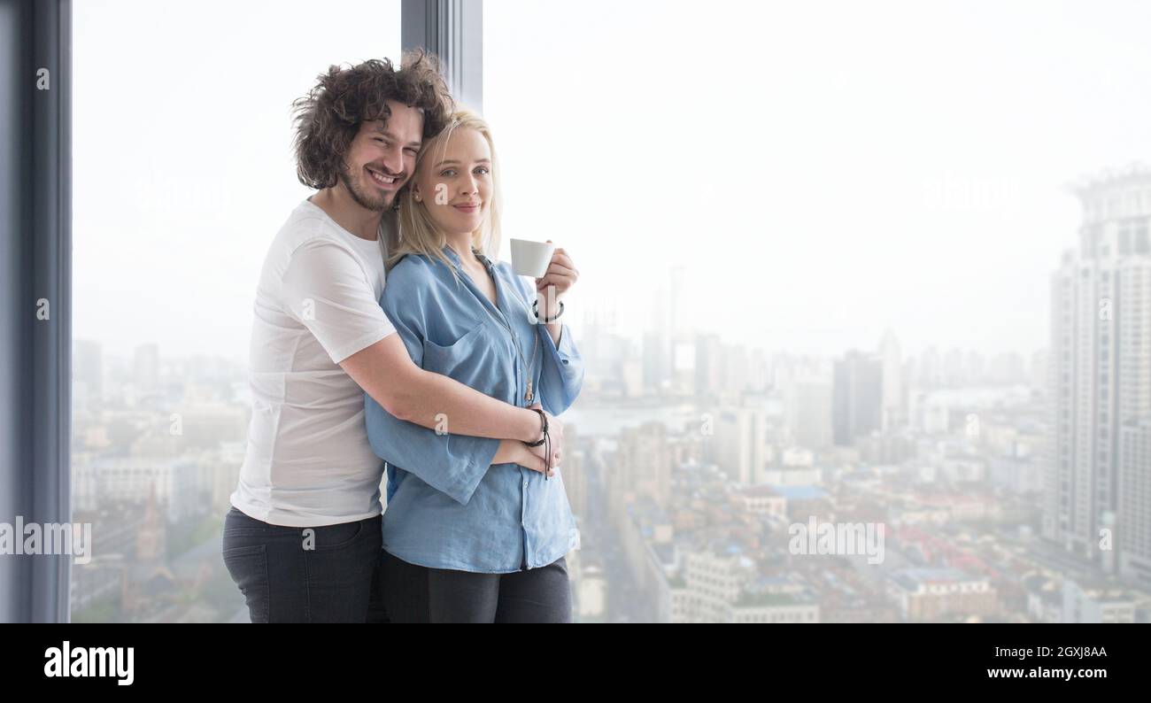 romantic happy young couple enjoying morning coffee by the window on ...
