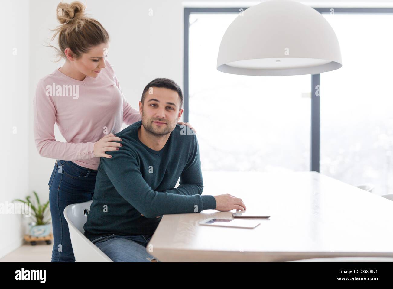 Portrait of a happy young beautiful couple hugging in their new home ...