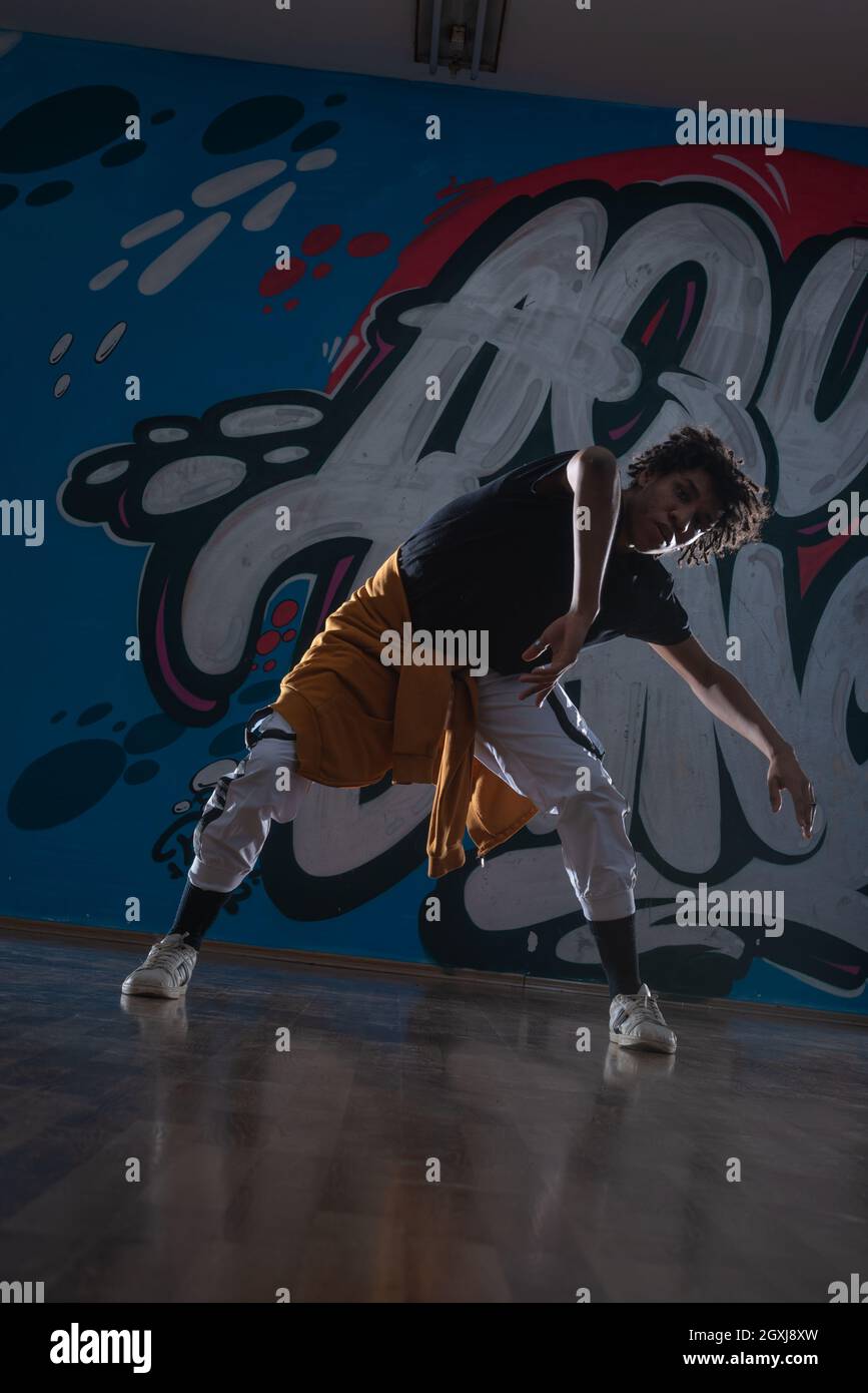 African American hip hop dancer (breakdancer) performing over graffiti ...