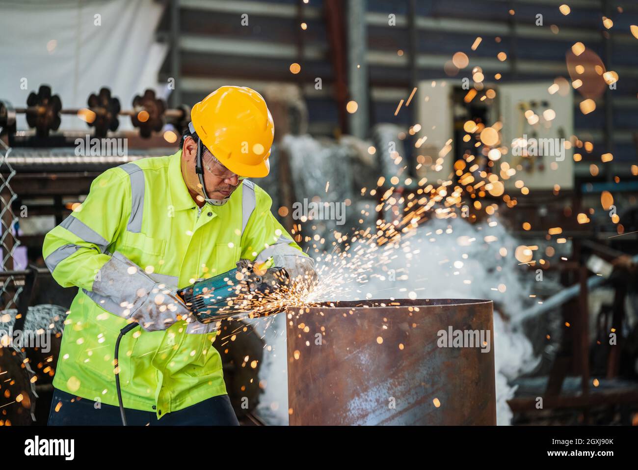 Industrial worker is working electric wheel grinding on steel structure ...