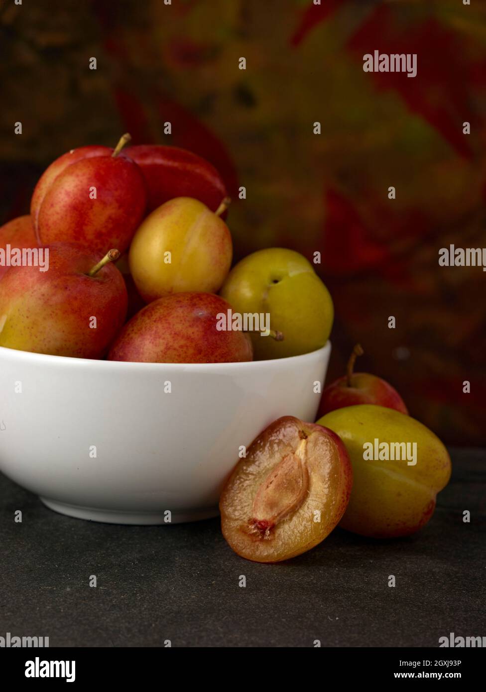 Market fresh sweet plums, natural food still life against plain ...
