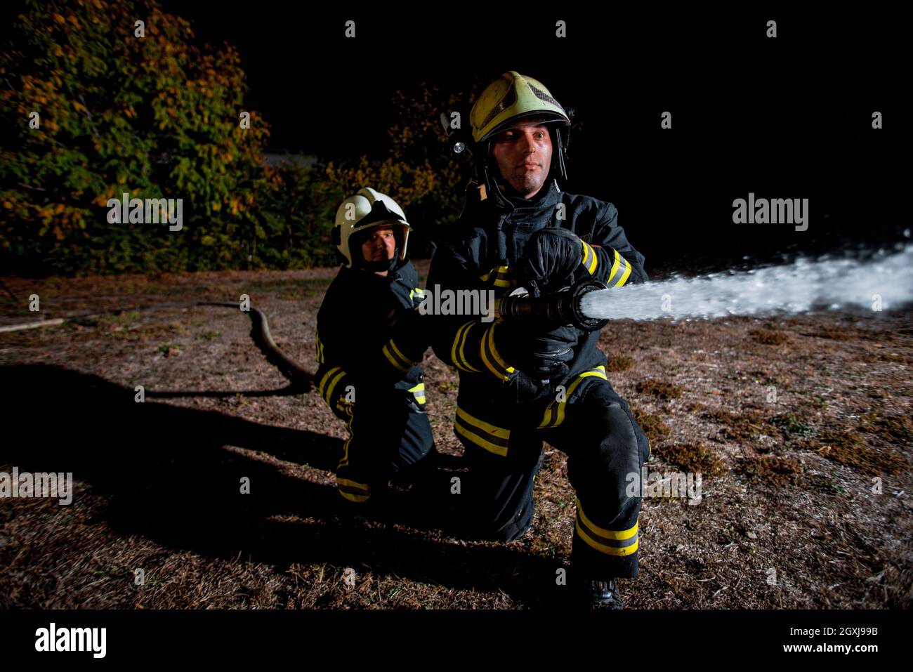 Fire brigade in full uniform with helmets fighting a forest fire Stock ...