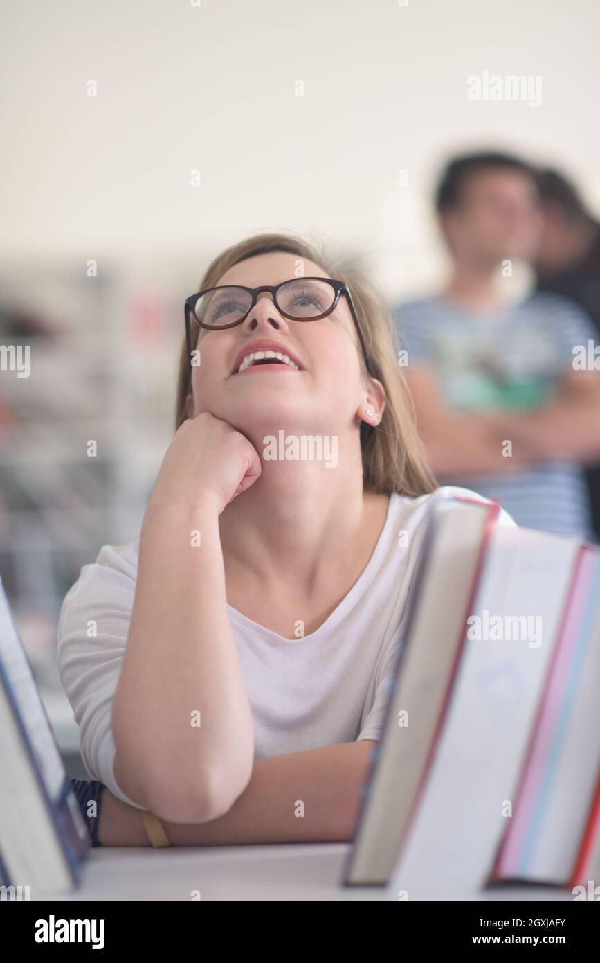 portrait of smart looking famale student girl in collage school library ...
