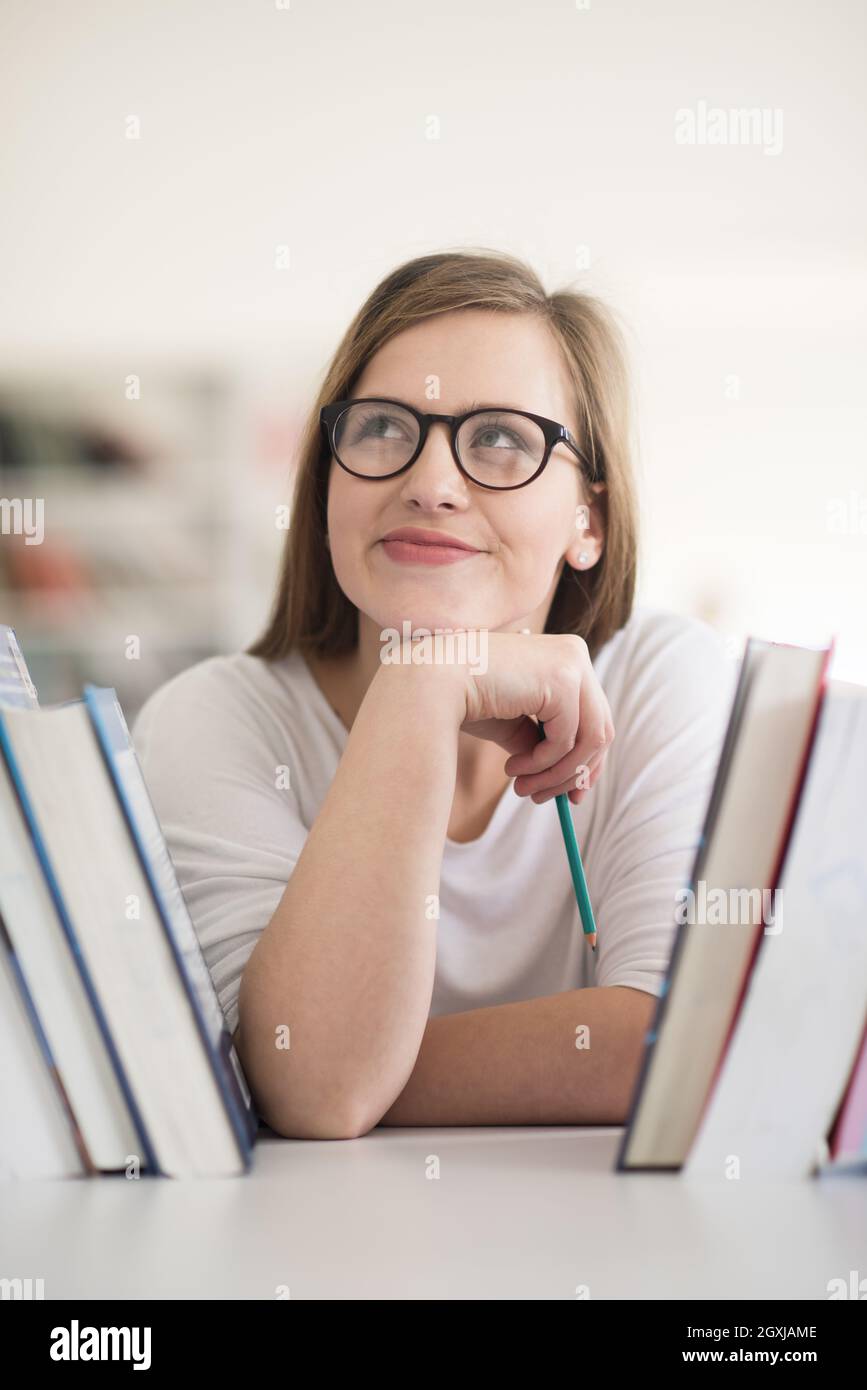 portrait of smart looking famale student girl in collage school library ...