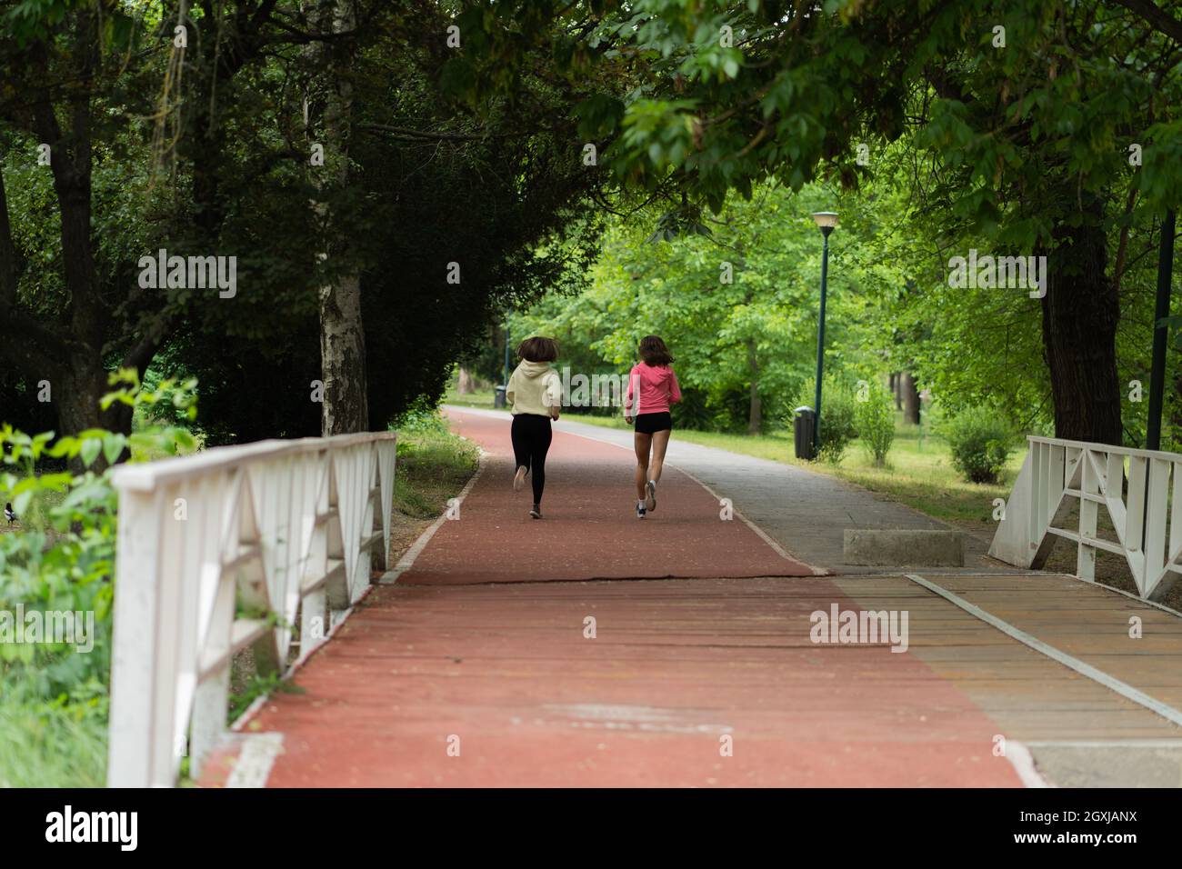 Two attractive girls are running together in the morning Stock Photo ...