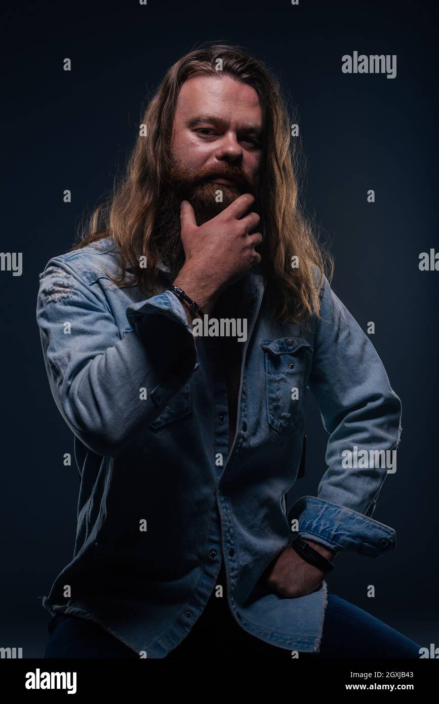 Close up portrait of handsome manly guy with beard posing in studio on ... Close up portrait of handsome manly guy with beard posing in studio on ...