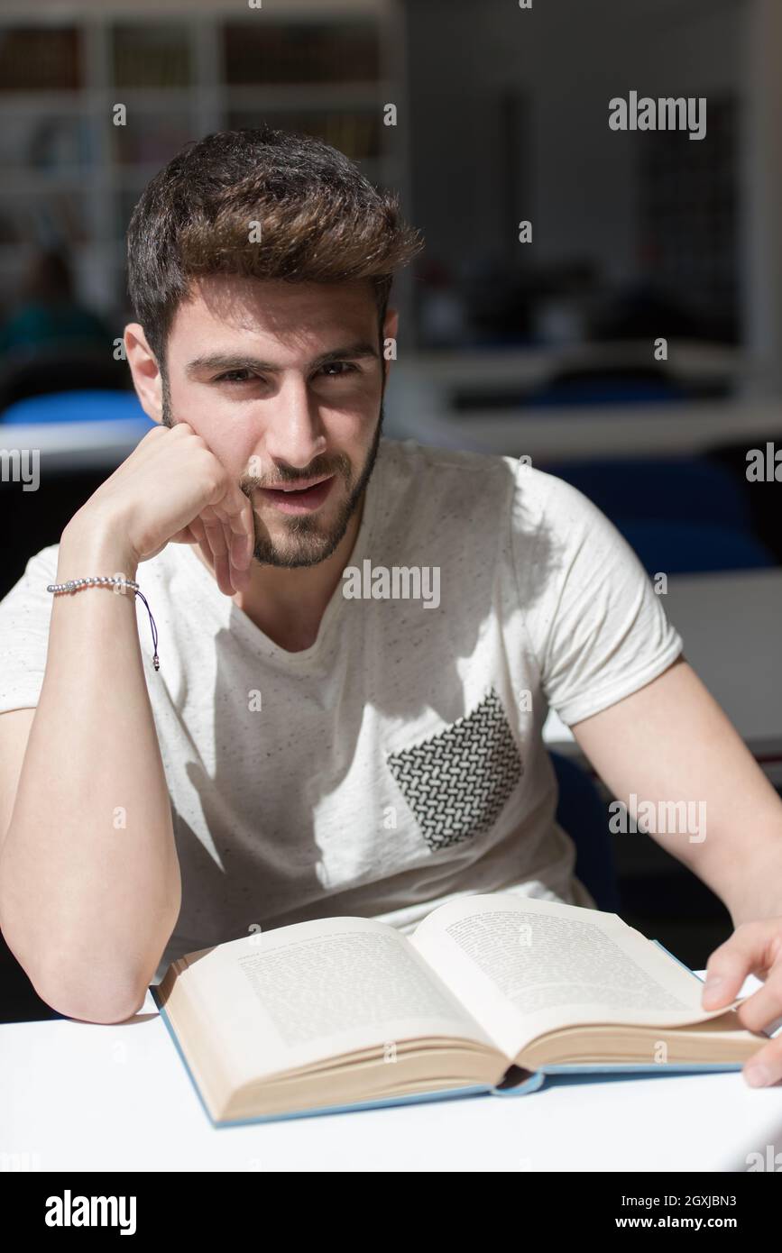 Student reading book in school library. Study lessons for exam. Hard ...