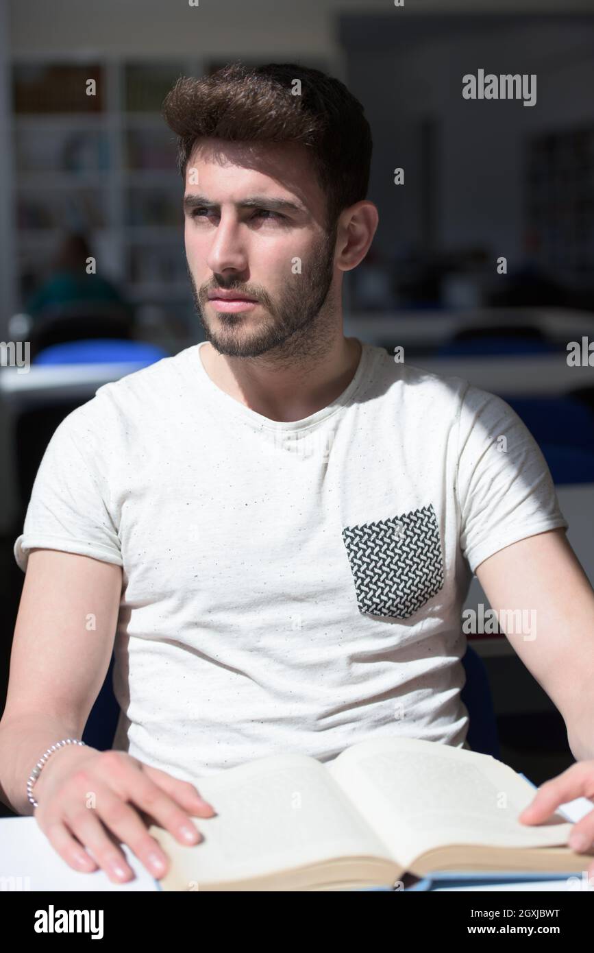 Student reading book in school library. Study lessons for exam. Hard ...