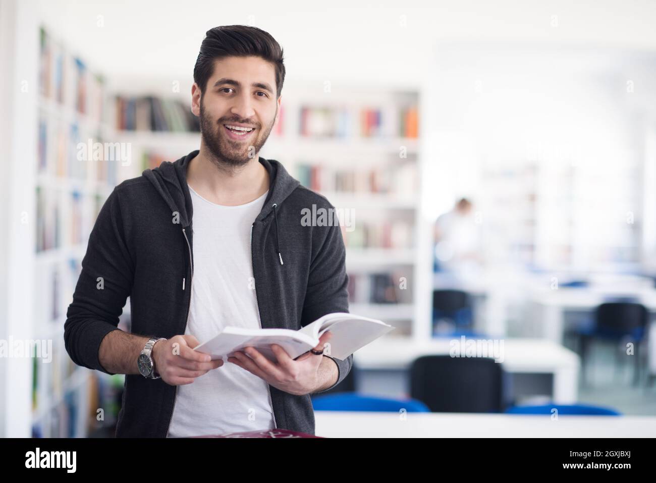 Portrait of happy student while reading book in school library. Study ...