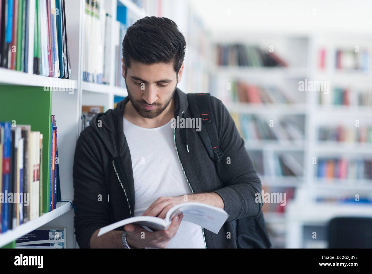 Portrait of happy student while reading book in school library. Study ...