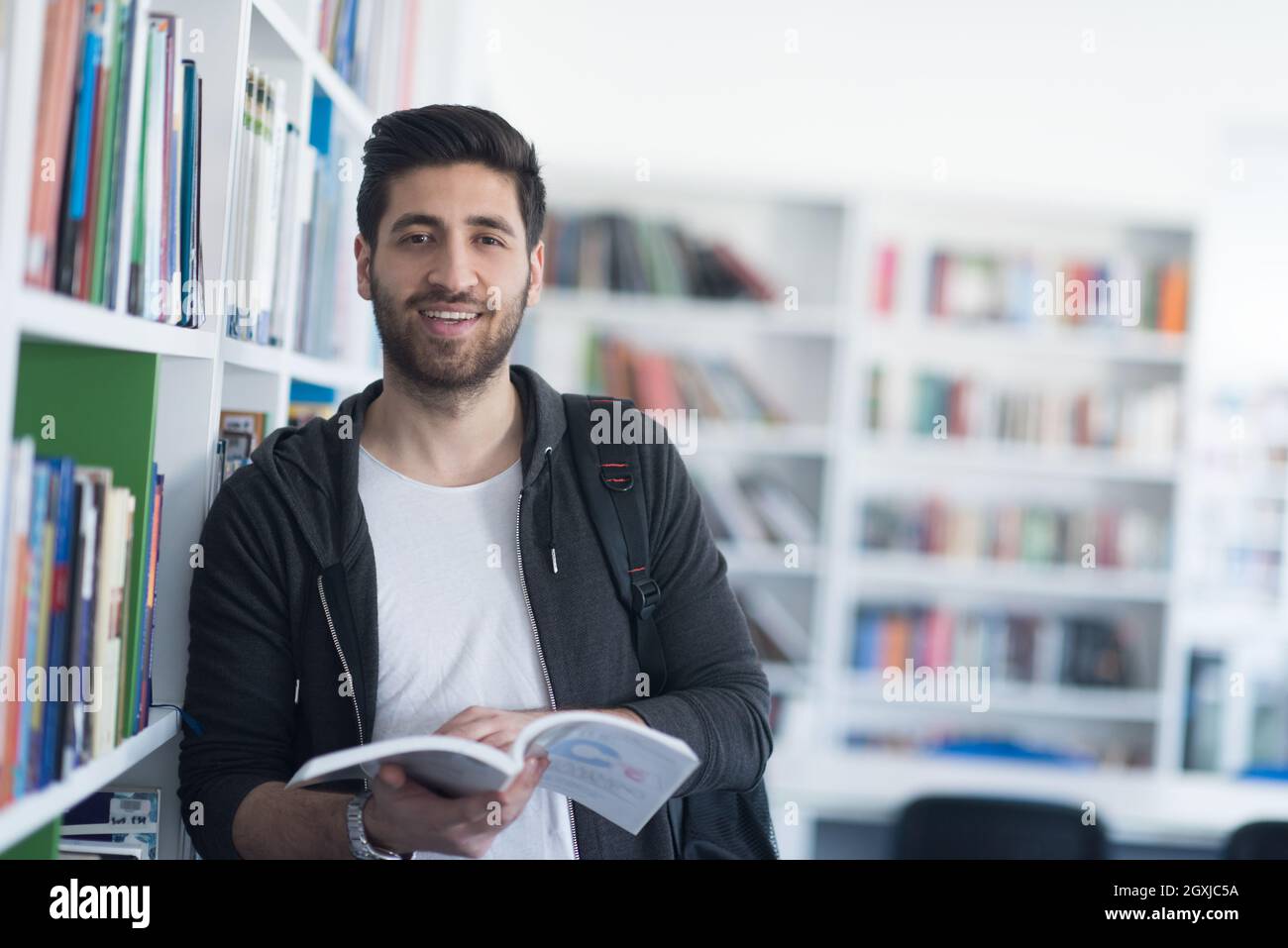 Portrait of happy student while reading book in school library. Study ...