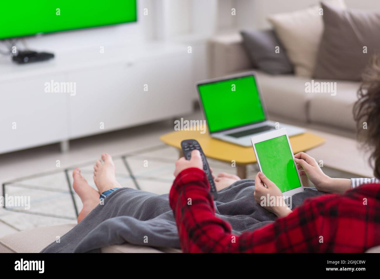 Young couple relaxing at home using tablet computers reading in the ...