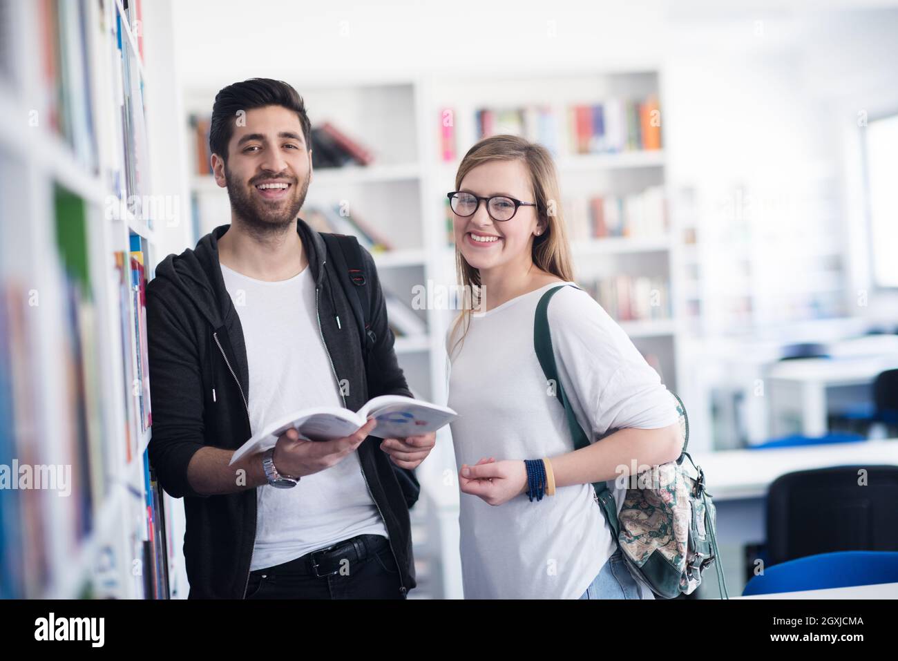 happy students couple in school library have discussion about book ...