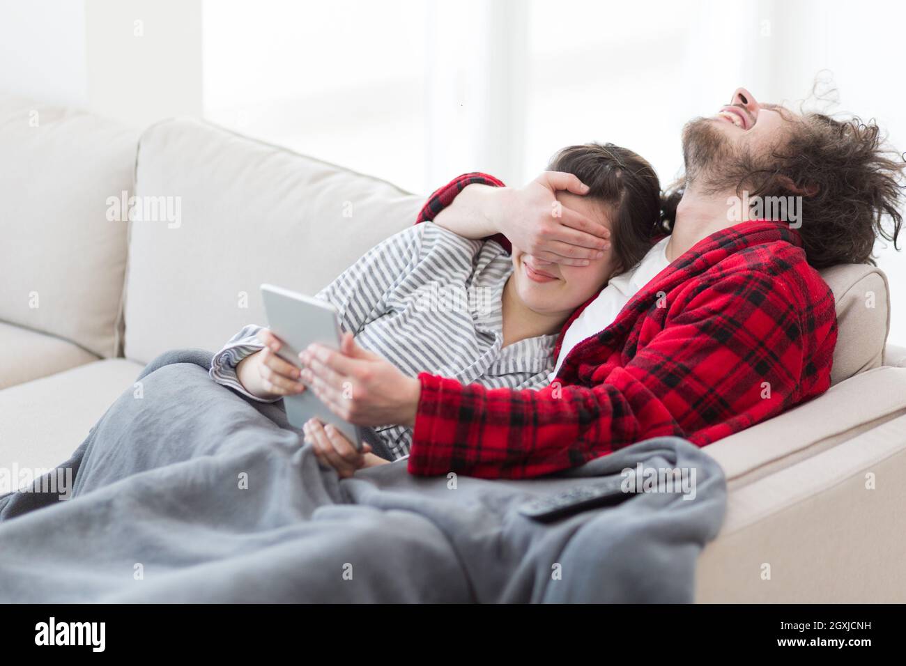 Young couple relaxing at home using tablet computers reading in the ...