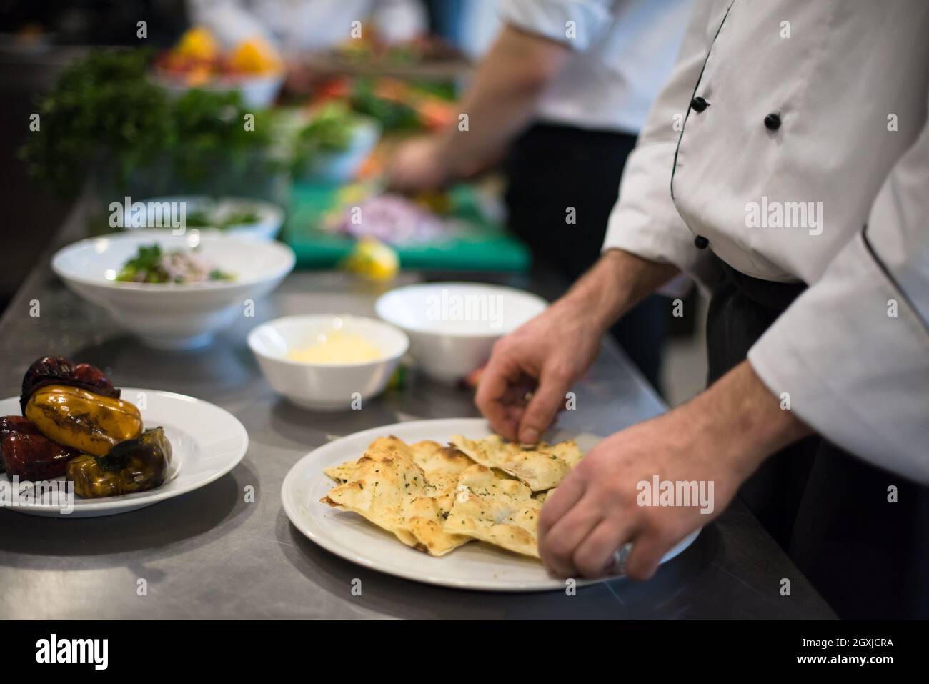 Professional team cooks and chefs preparing meal at busy hotel or ...
