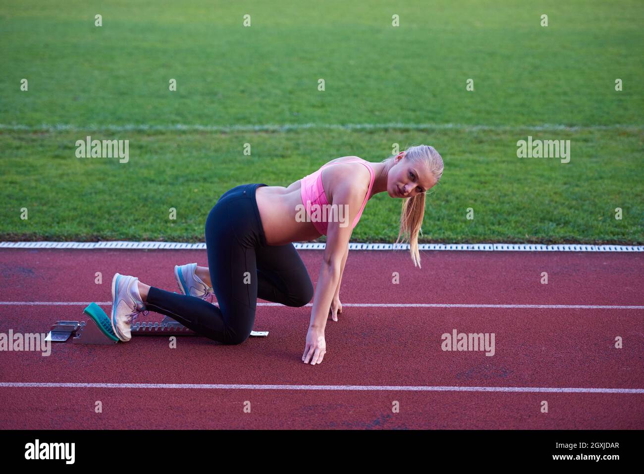 pixelated design of woman sprinter leaving starting blocks on the ...