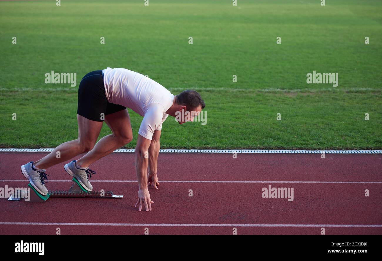 Sprinter leaving starting blocks on the running track. Explosive start ...
