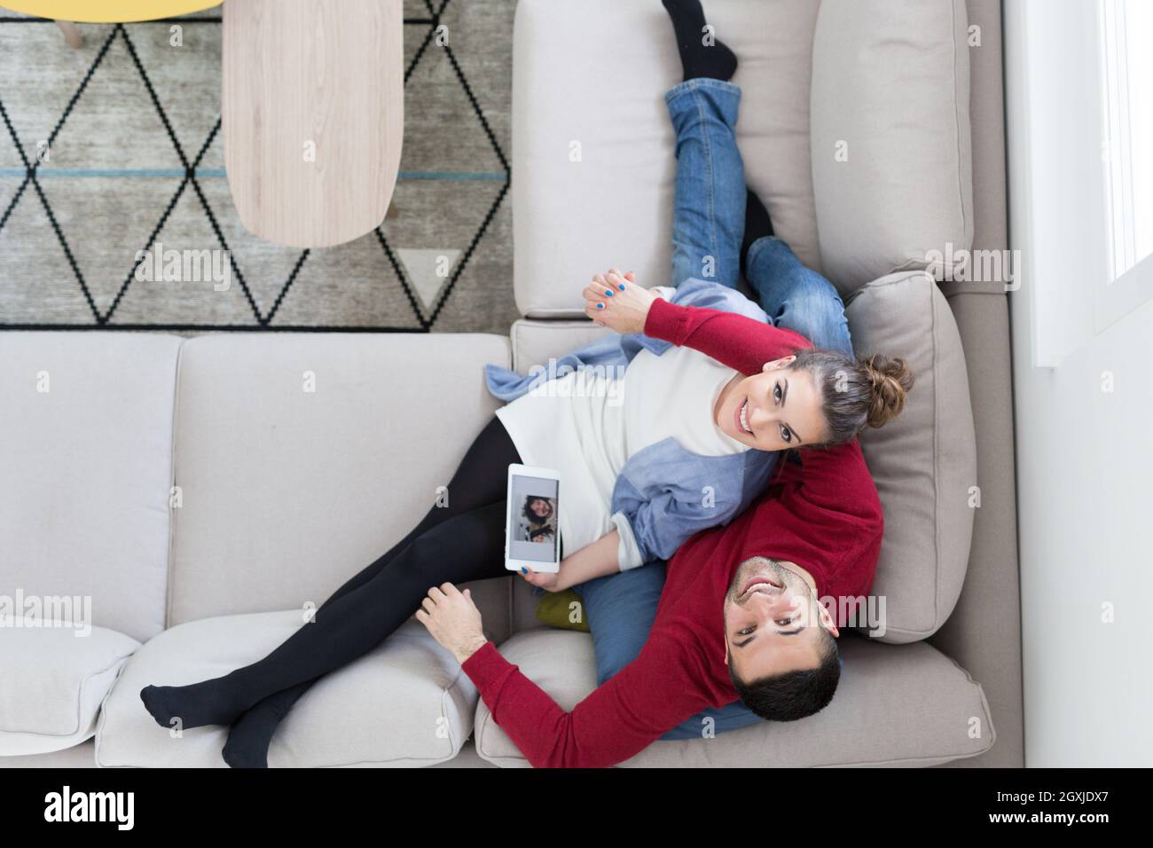 Young couple relaxing at home using tablet computers reading in the ...