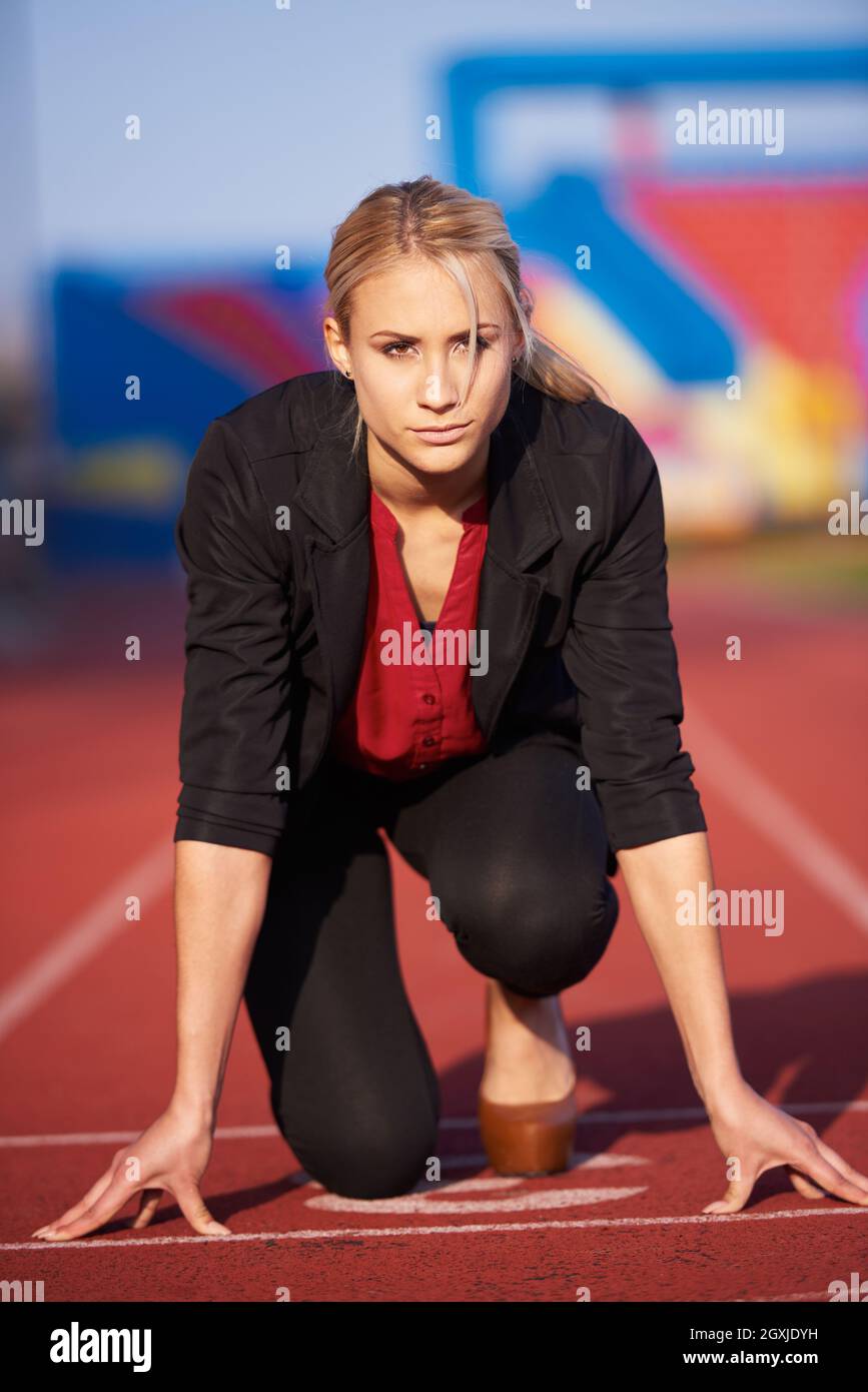 business woman in start position ready to run and sprint on athletics ...