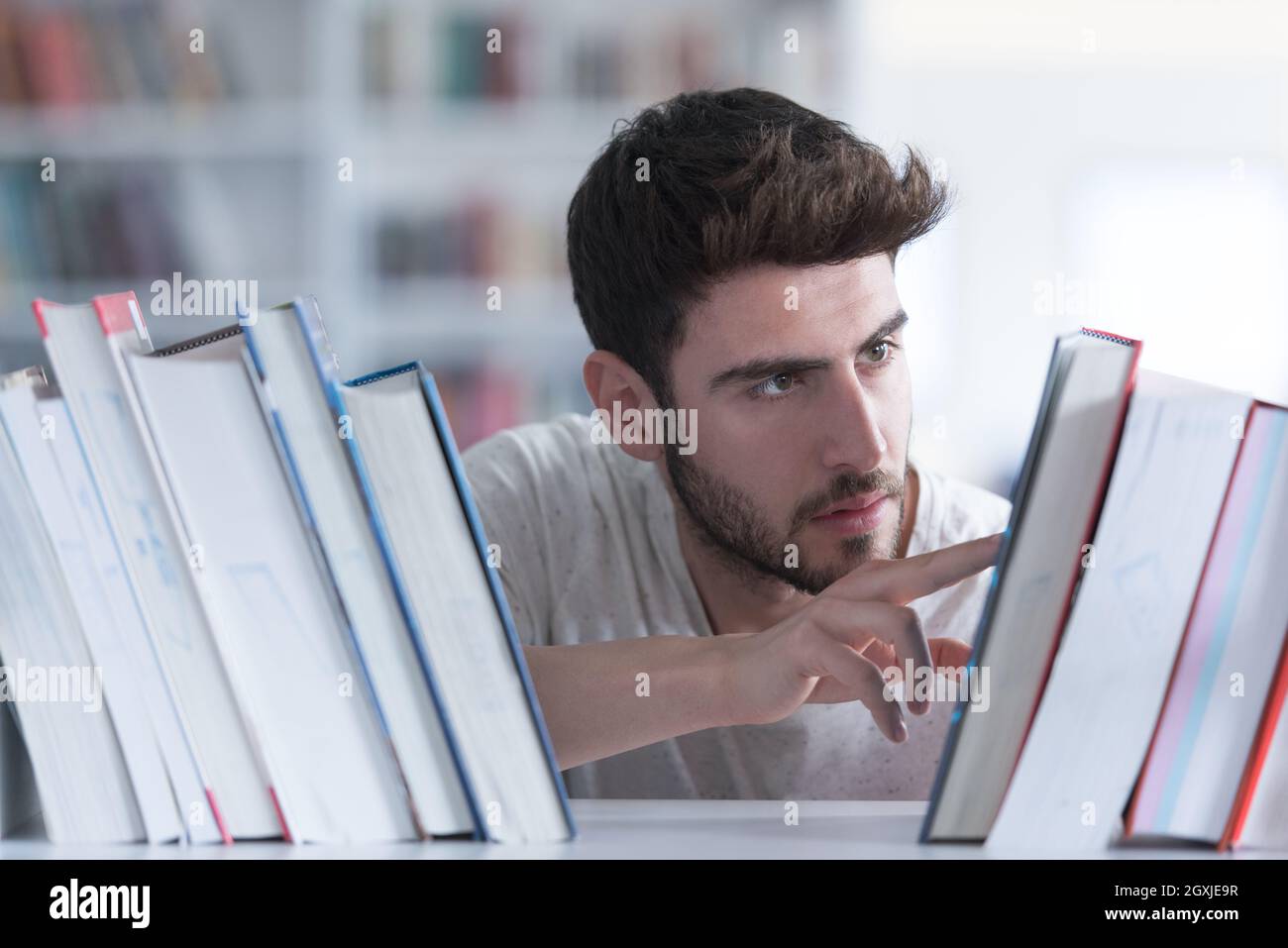 Student reading book in school library. Study lessons for exam. Hard ...