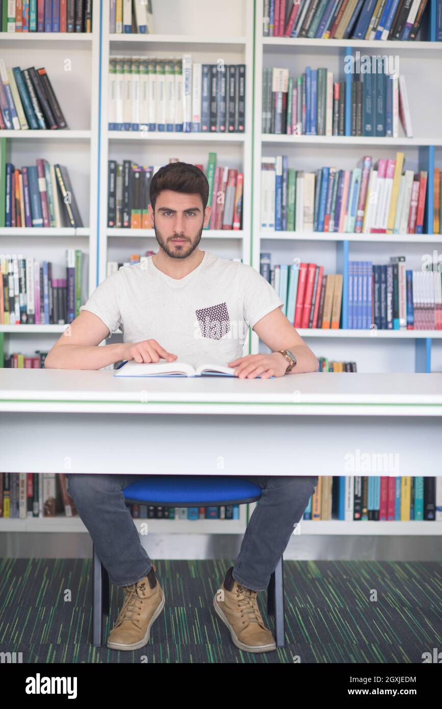 Student reading book in school library. Study lessons for exam. Hard ...