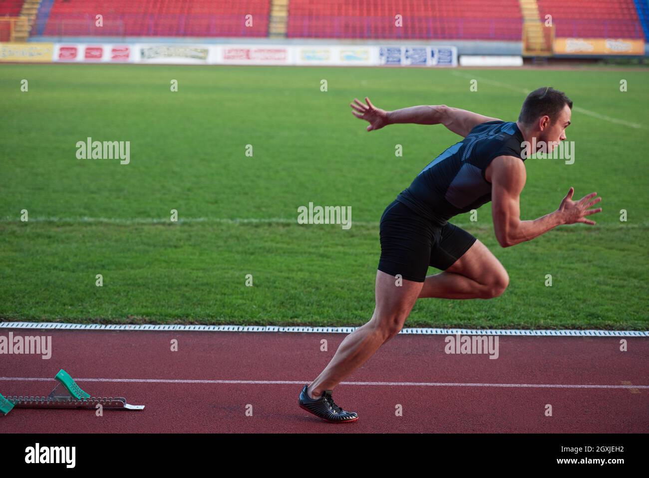 Sprinter leaving starting blocks on the running track. Explosive start ...
