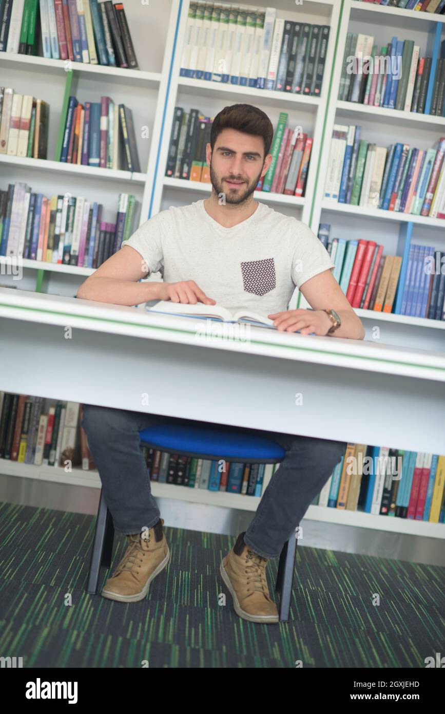 Student reading book in school library. Study lessons for exam. Hard ...