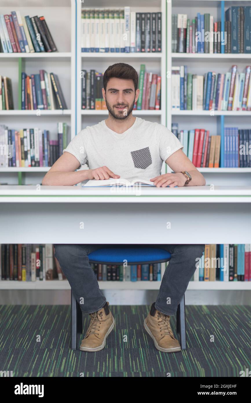 Student reading book in school library. Study lessons for exam. Hard ...