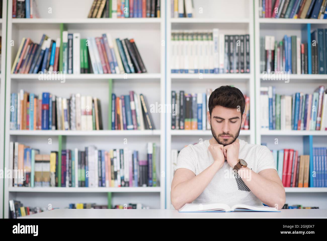 Student reading book in school library. Study lessons for exam. Hard ...