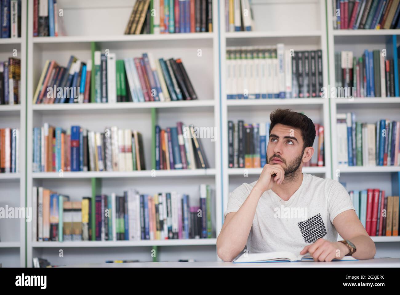 Student reading book in school library. Study lessons for exam. Hard ...