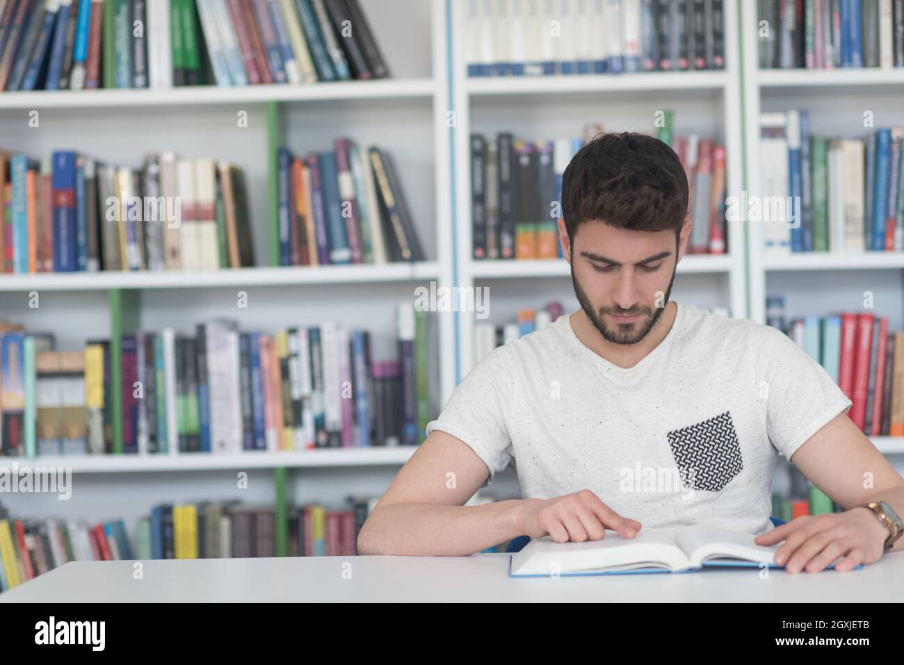 Student reading book in school library. Study lessons for exam. Hard ...
