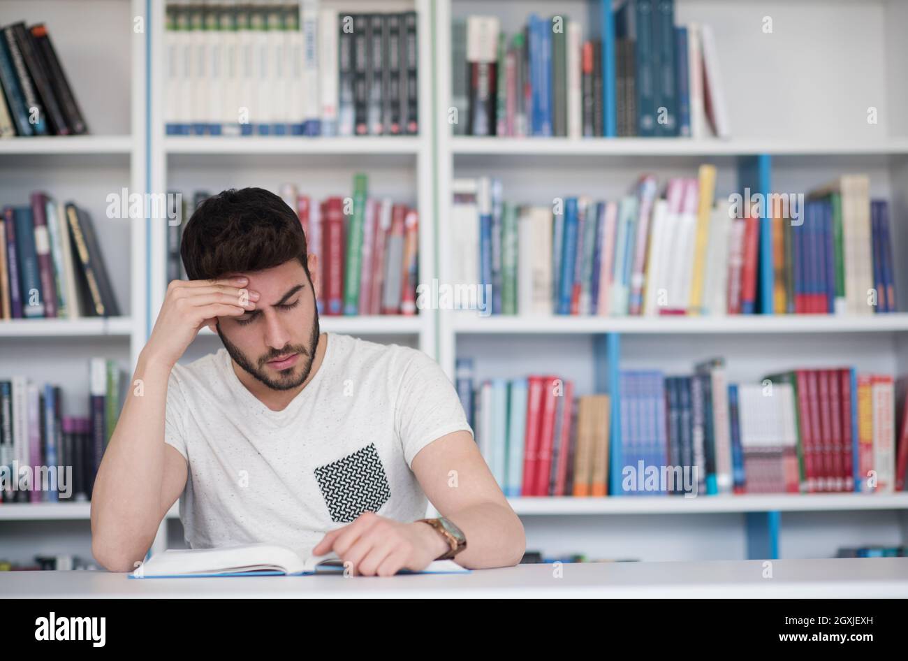 Student reading book in school library. Study lessons for exam. Hard ...