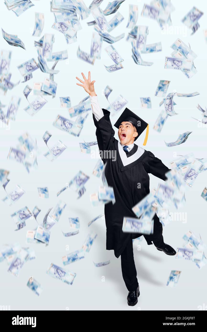 Happy male graduate student running under money rain Stock Photo - Alamy