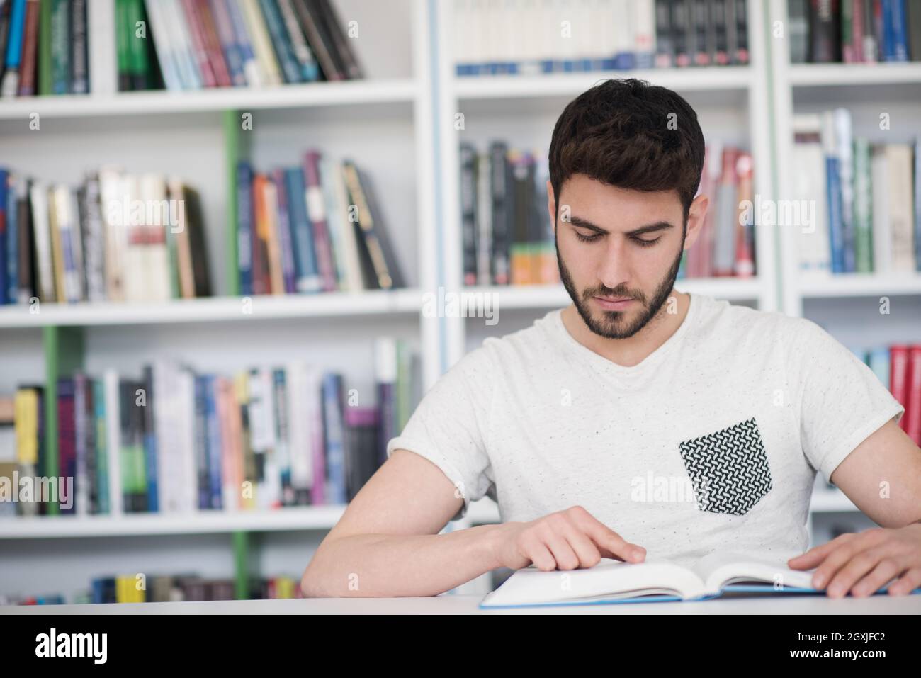 Student reading book in school library. Study lessons for exam. Hard ...