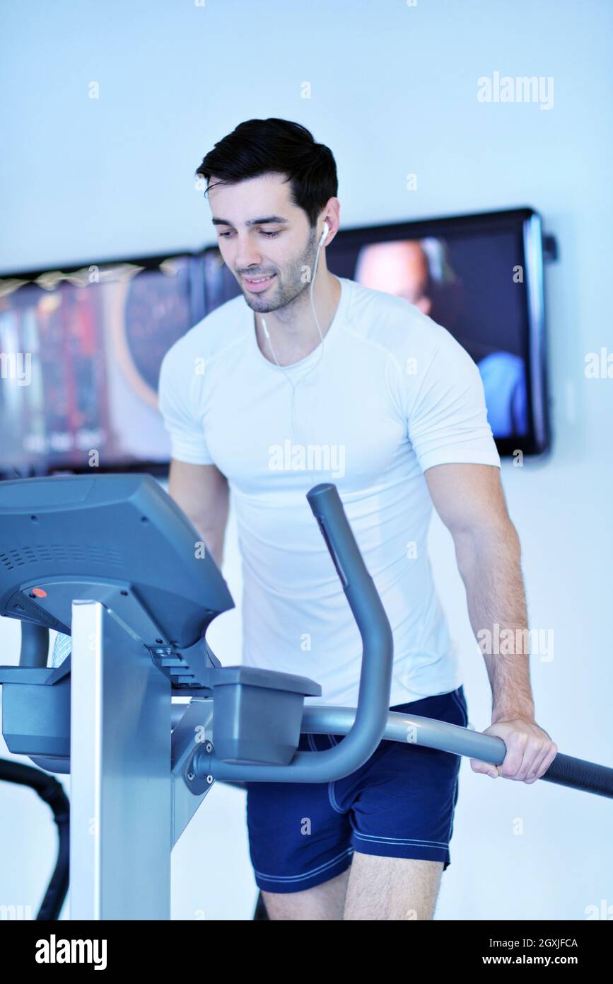 Handsome man running on the treadmill in modern gym Stock Photo - Alamy