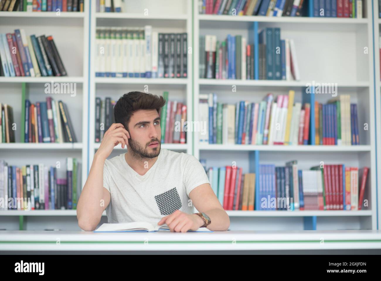 Student reading book in school library. Study lessons for exam. Hard ...