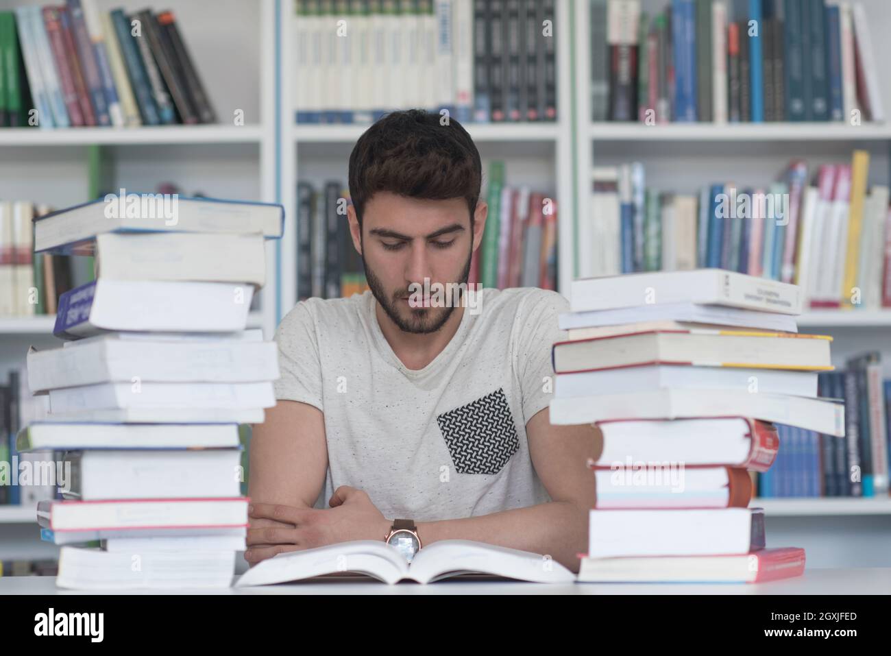 Student reading book in school library. Study lessons for exam. Hard ...
